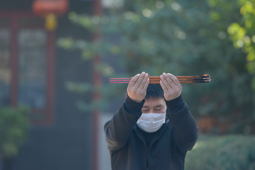 Lijun Shi - Local resident prays for peace in a temple in China ...