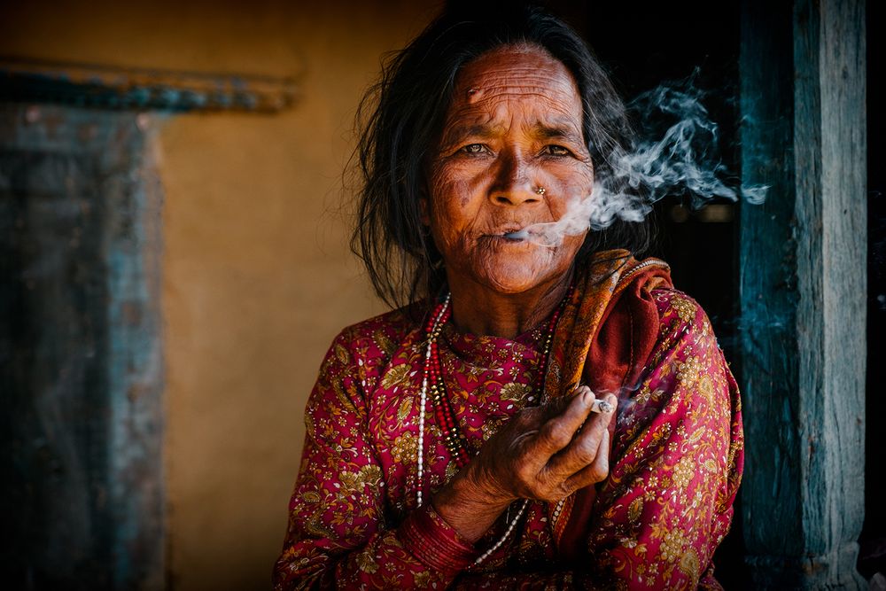 Adrian Popan - Portrait of a Nepali woman smoking a cigarette | LensCulture