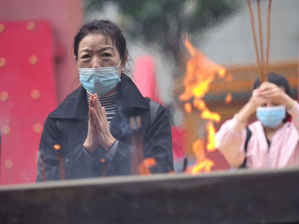 Lijun Shi - Local resident prays for peace in a temple in China ...